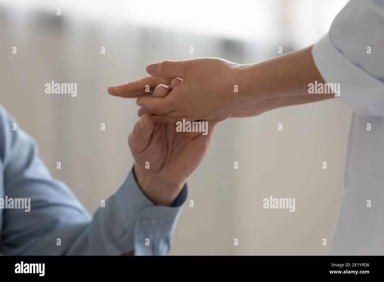 Young kind female doctor supporting old patient Stock Photo - Alamy