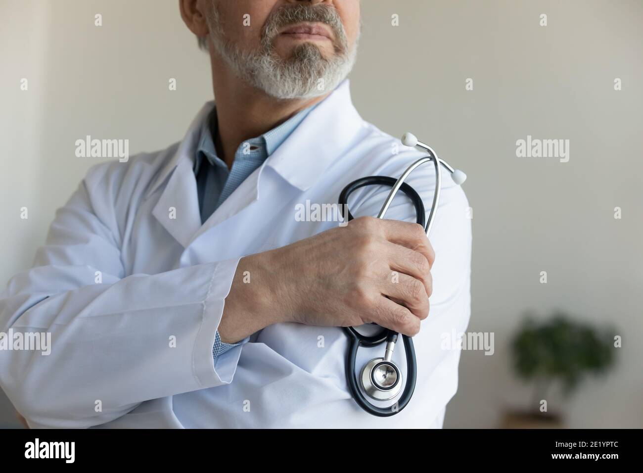 Close up serious middle aged male cardiologist holding stethoscope ...