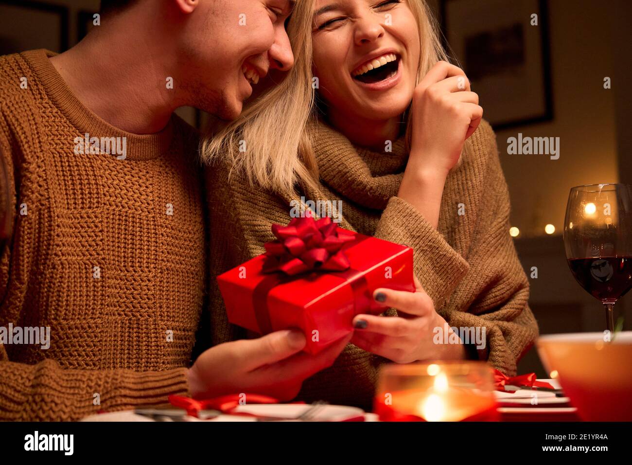 Happy young woman receiving gift box from loving man on Valentines day ...
