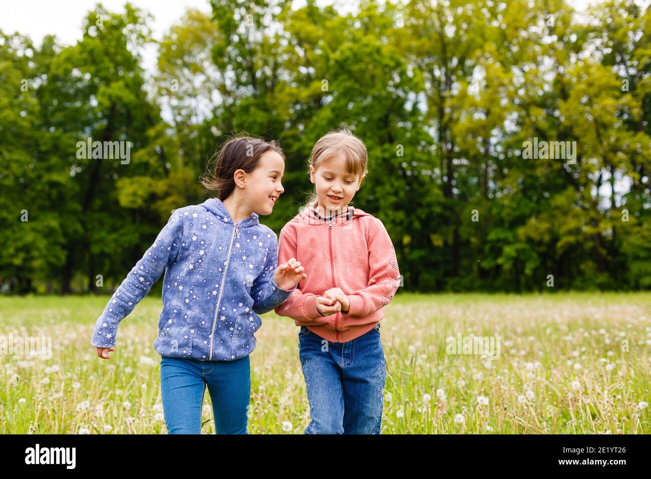 Two sisters hug one another outdoors, happy family Stock Photo - Alamy