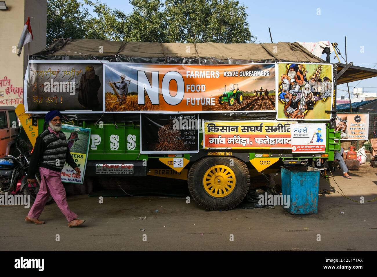 A protester walking past tractor with banners during a farmers' protest ...