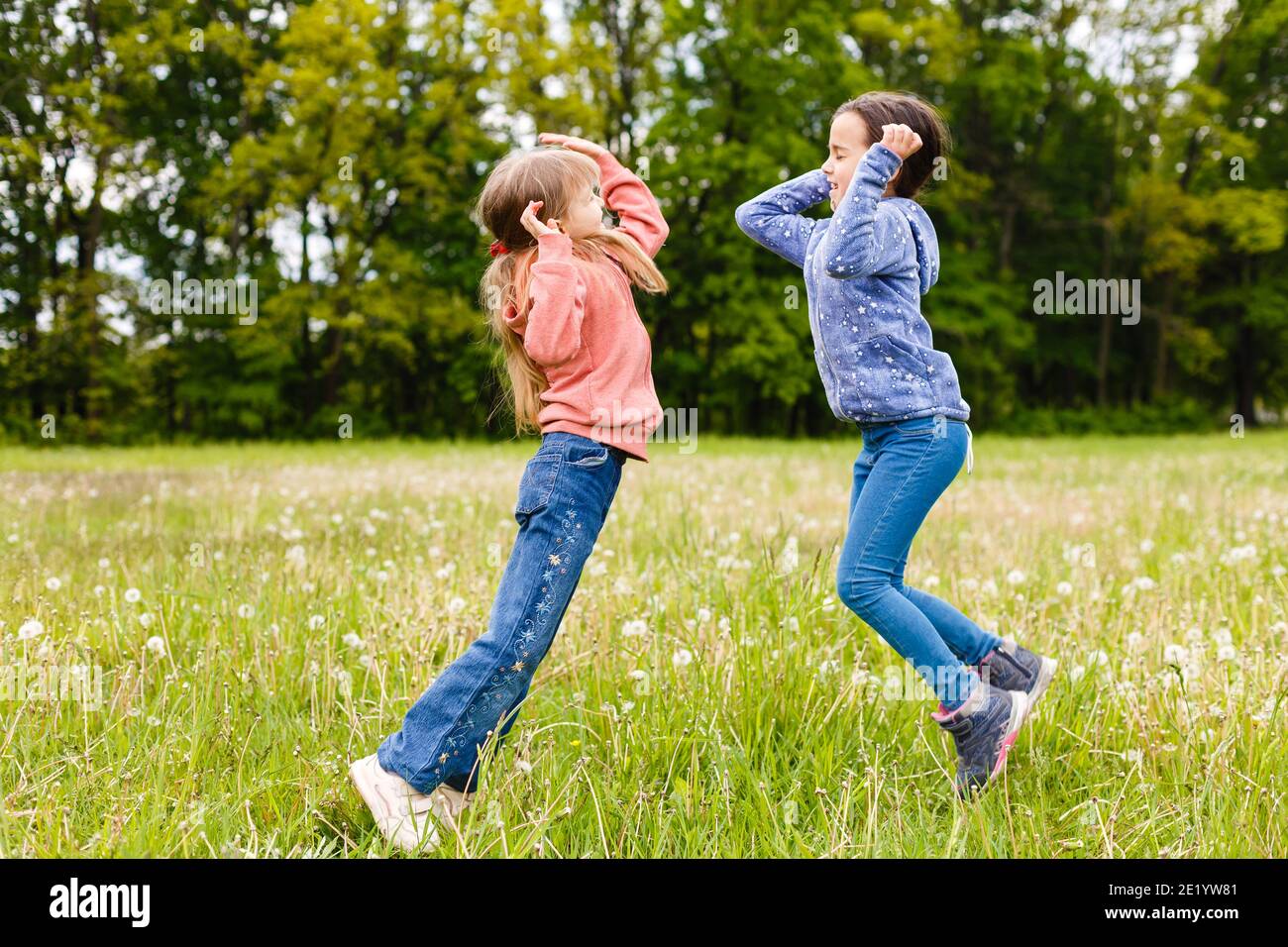 Two sisters hug one another outdoors, happy family Stock Photo - Alamy