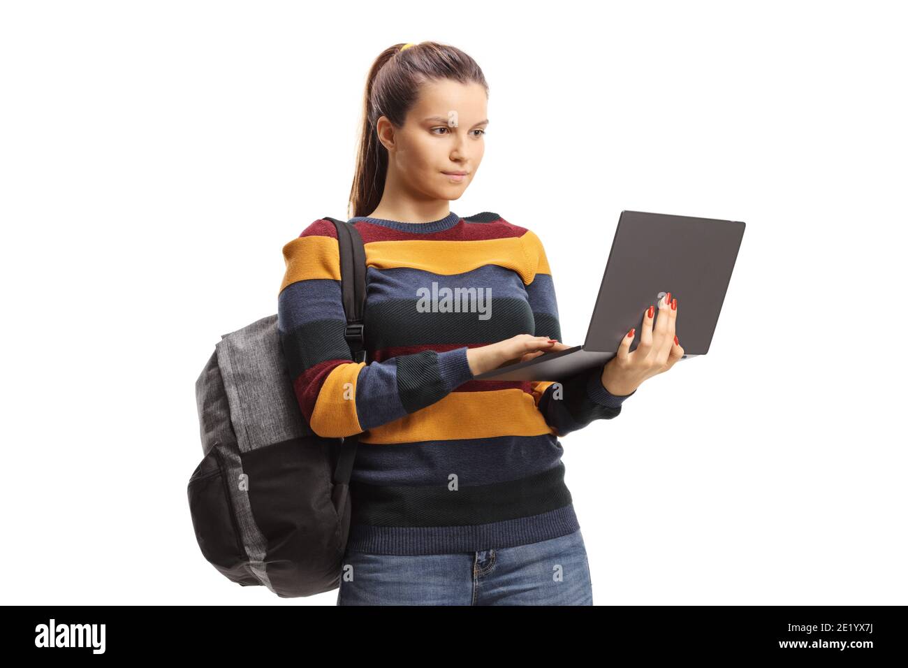 Full length portrait of a female student standing and using a laptop ...