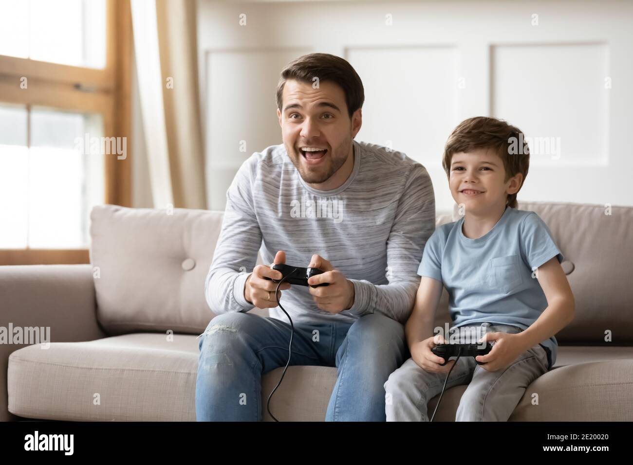 Happy dad and little son play video game Stock Photo - Alamy