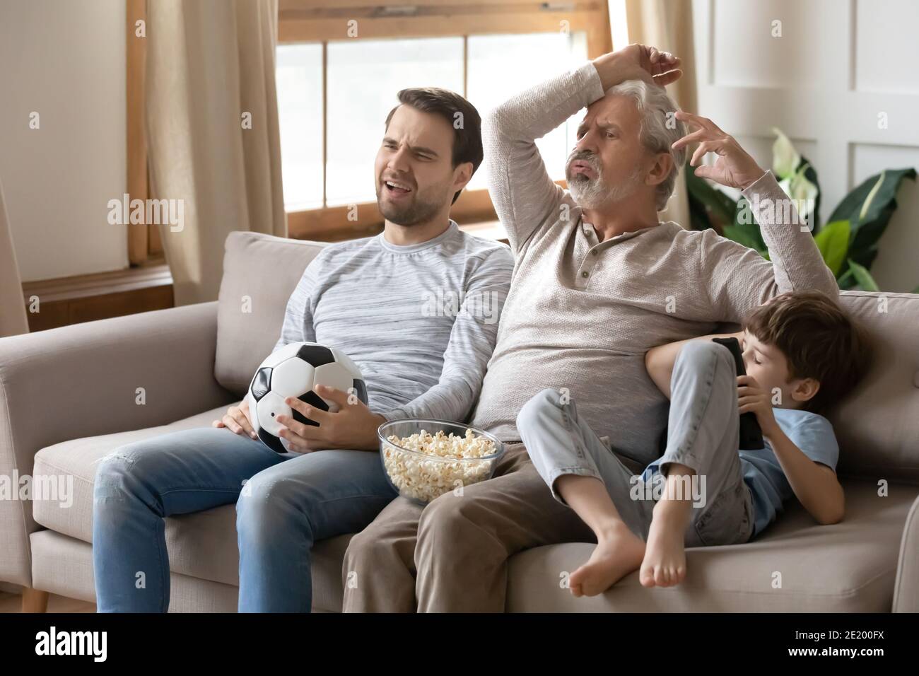 Three generations family watching tv hi-res stock photography and ...