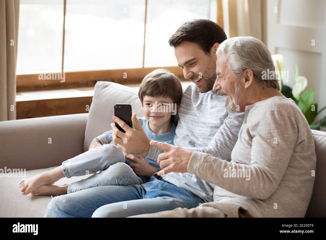 Happy three generations of men use smartphone at home Stock Photo - Alamy
