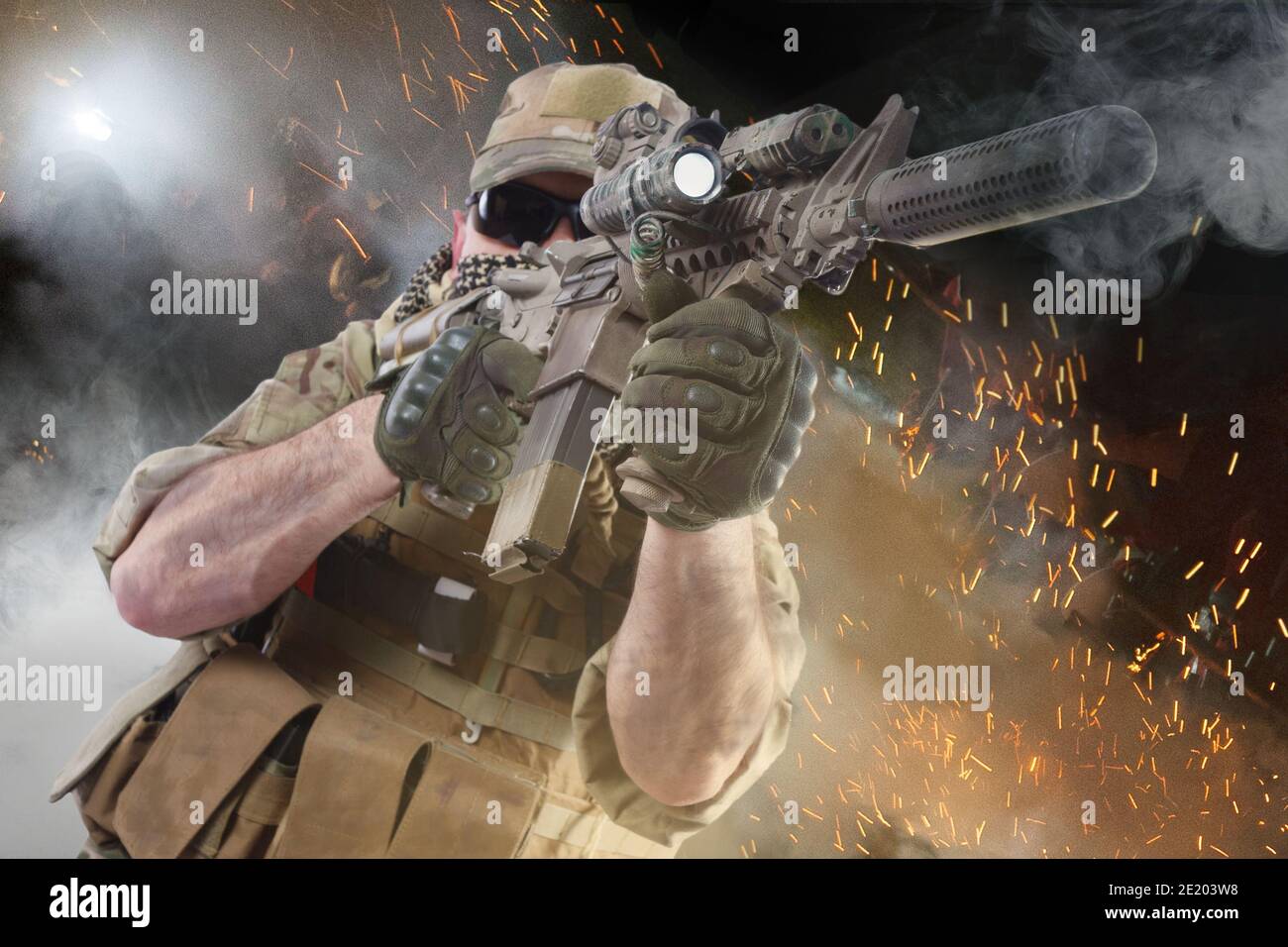 Soldier of special forces with carbine M4 in action. Flame and smoke on ...