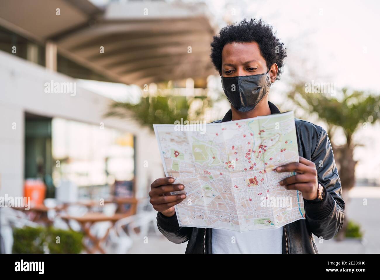 Tourist man looking for directions on map Stock Photo - Alamy