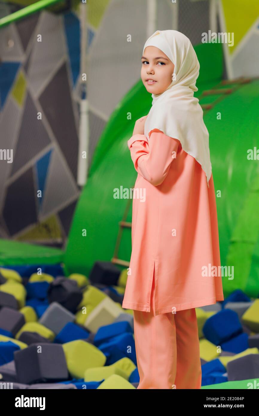 Side portrait of a little Muslim girl wearing a hijab. Concept of ...