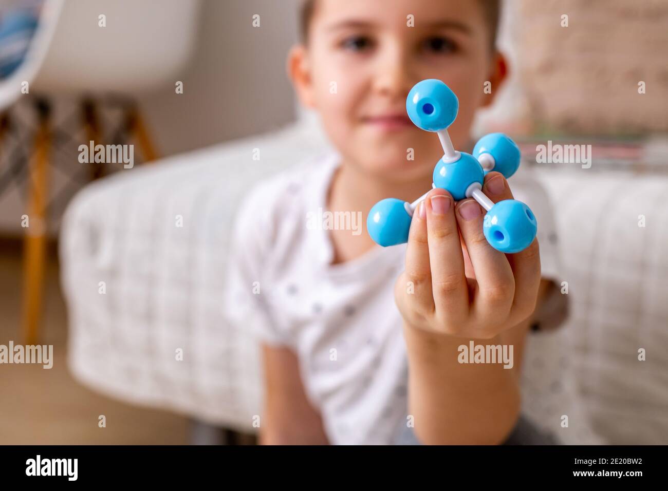 The boy collects a water molecule model from the constructor using the ...