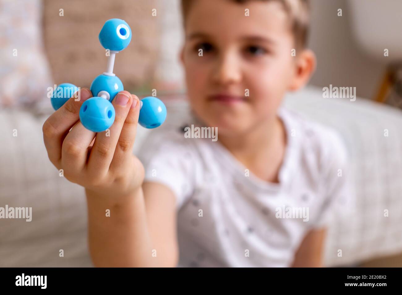 The boy collects a water molecule model from the constructor using the ...