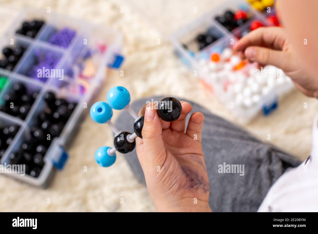 The boy collects a propane molecule model from the constructor using ...