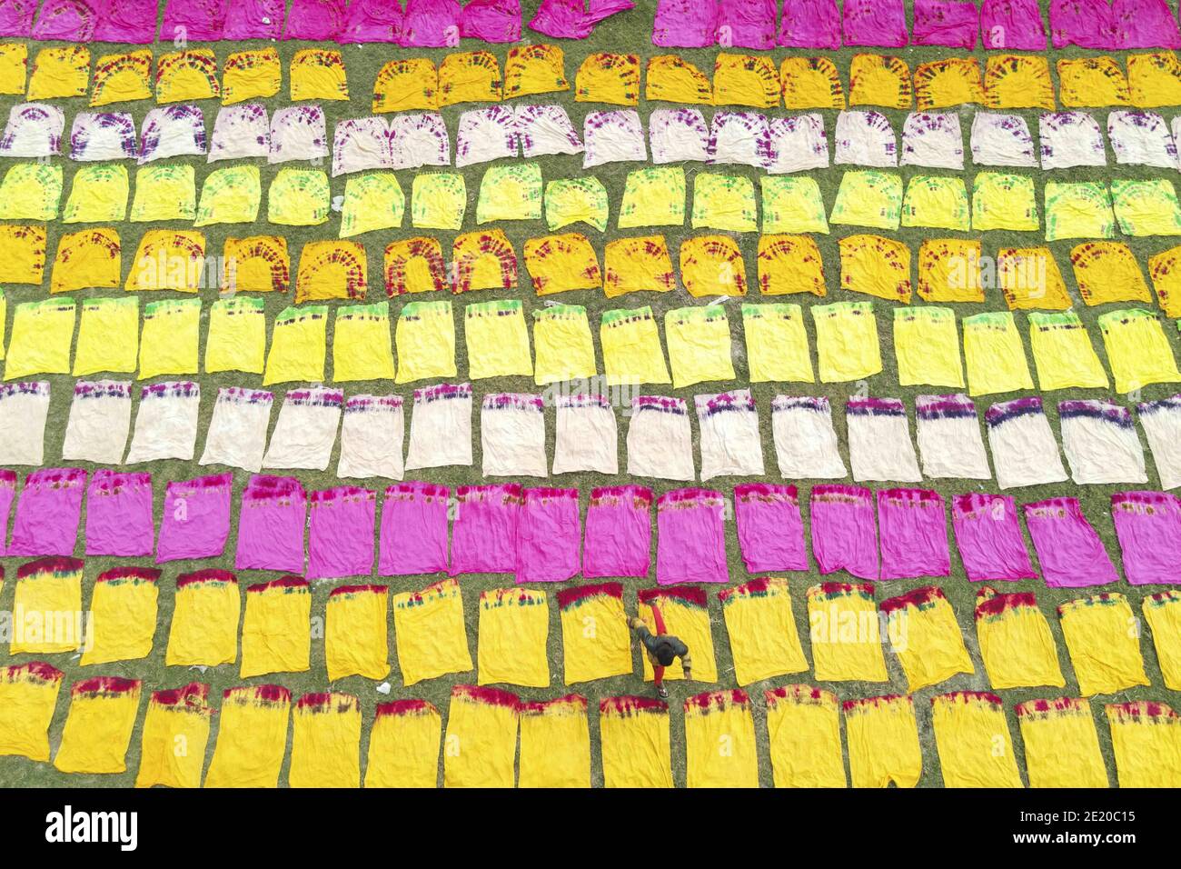 Fabrics lie on the ground to dry after a dyeing process at a factory in ...