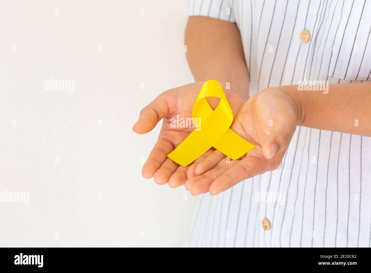 Hands holding gold ribbon on white isolated background with copy space ...