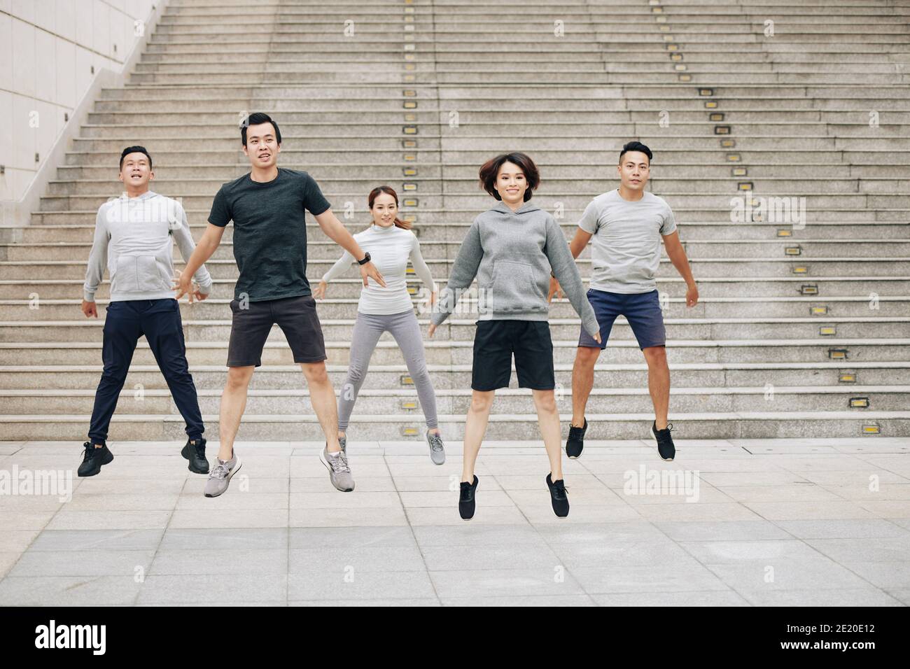 Asian people doing squat jumps Stock Photo - Alamy