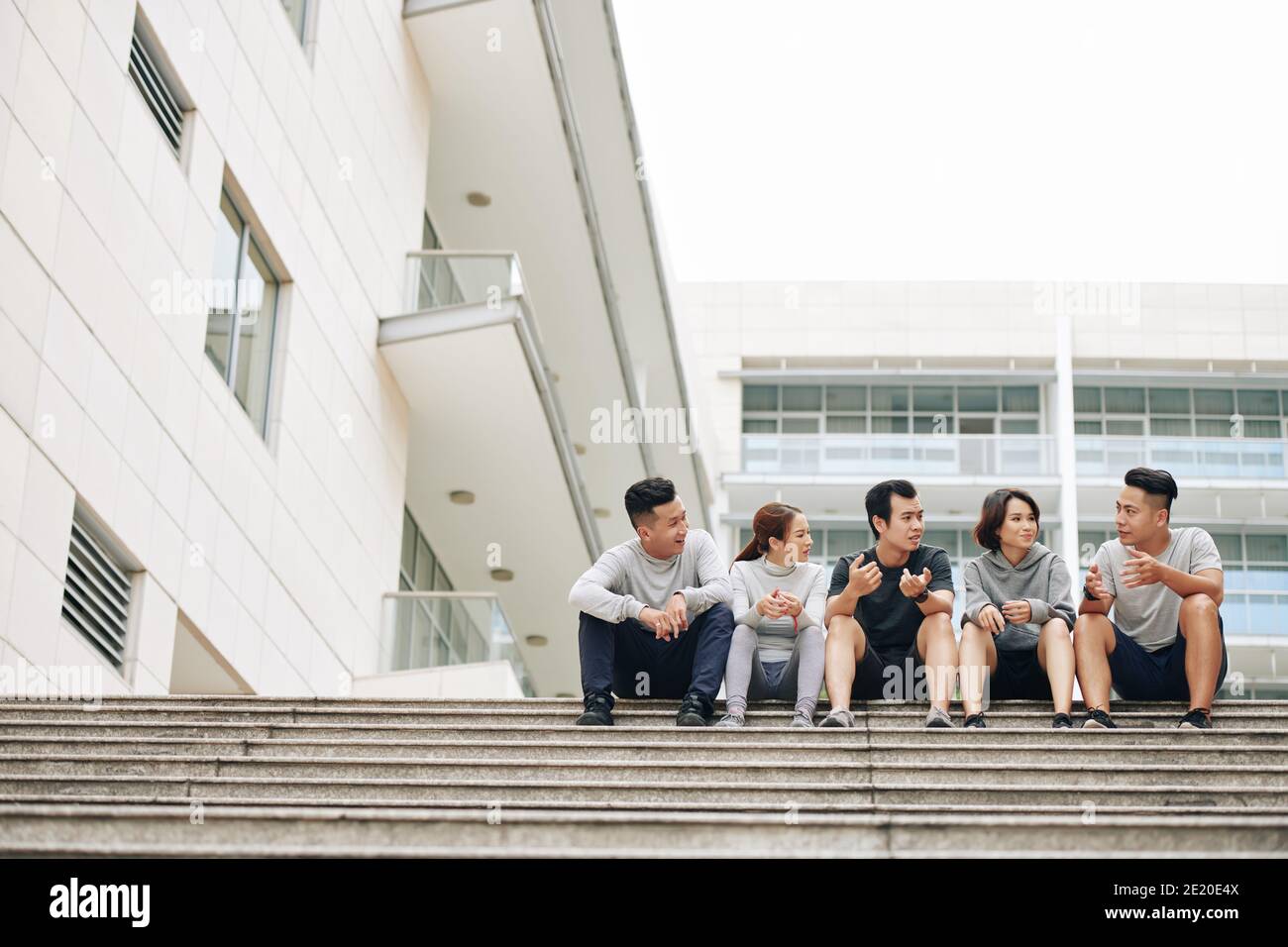 Group of friends sitting on steps and discussing healthy lifestyle ...