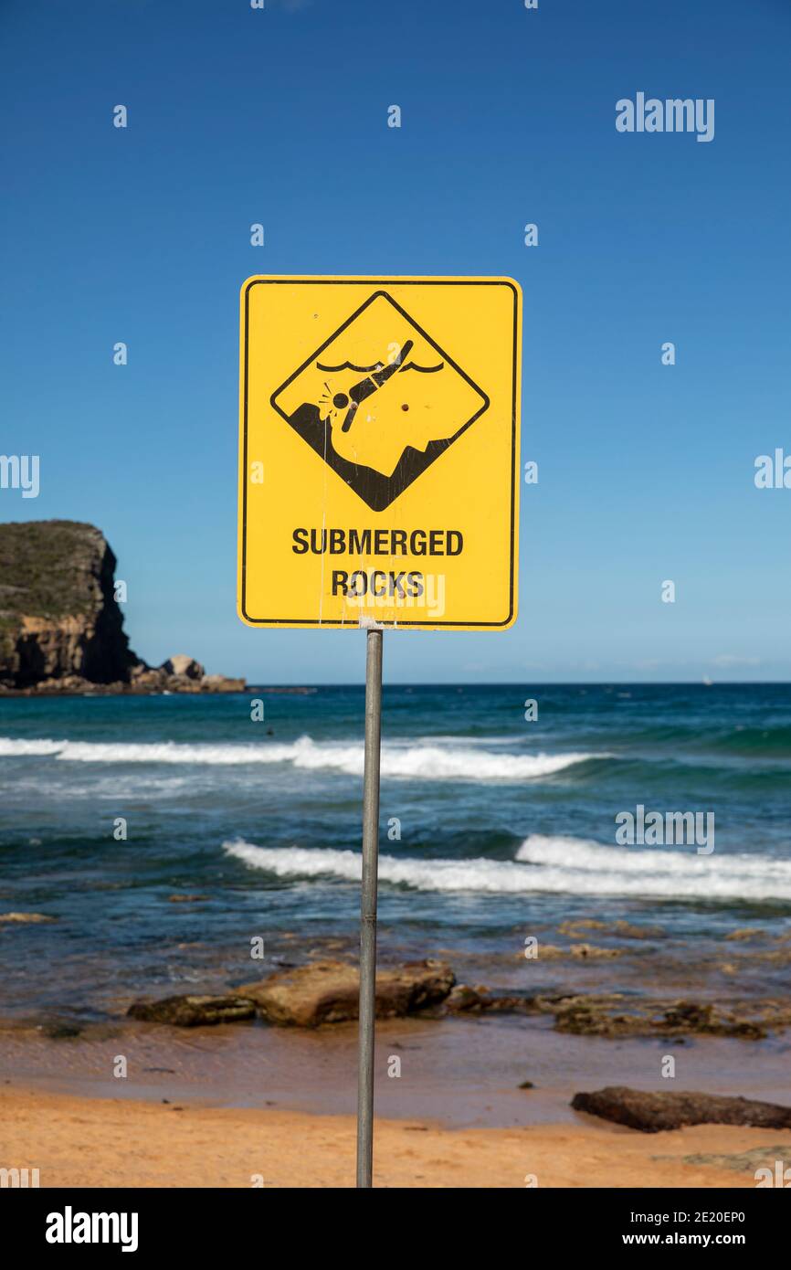 Warning sign of submerged rocks close to shore on Avalon Beach in ...