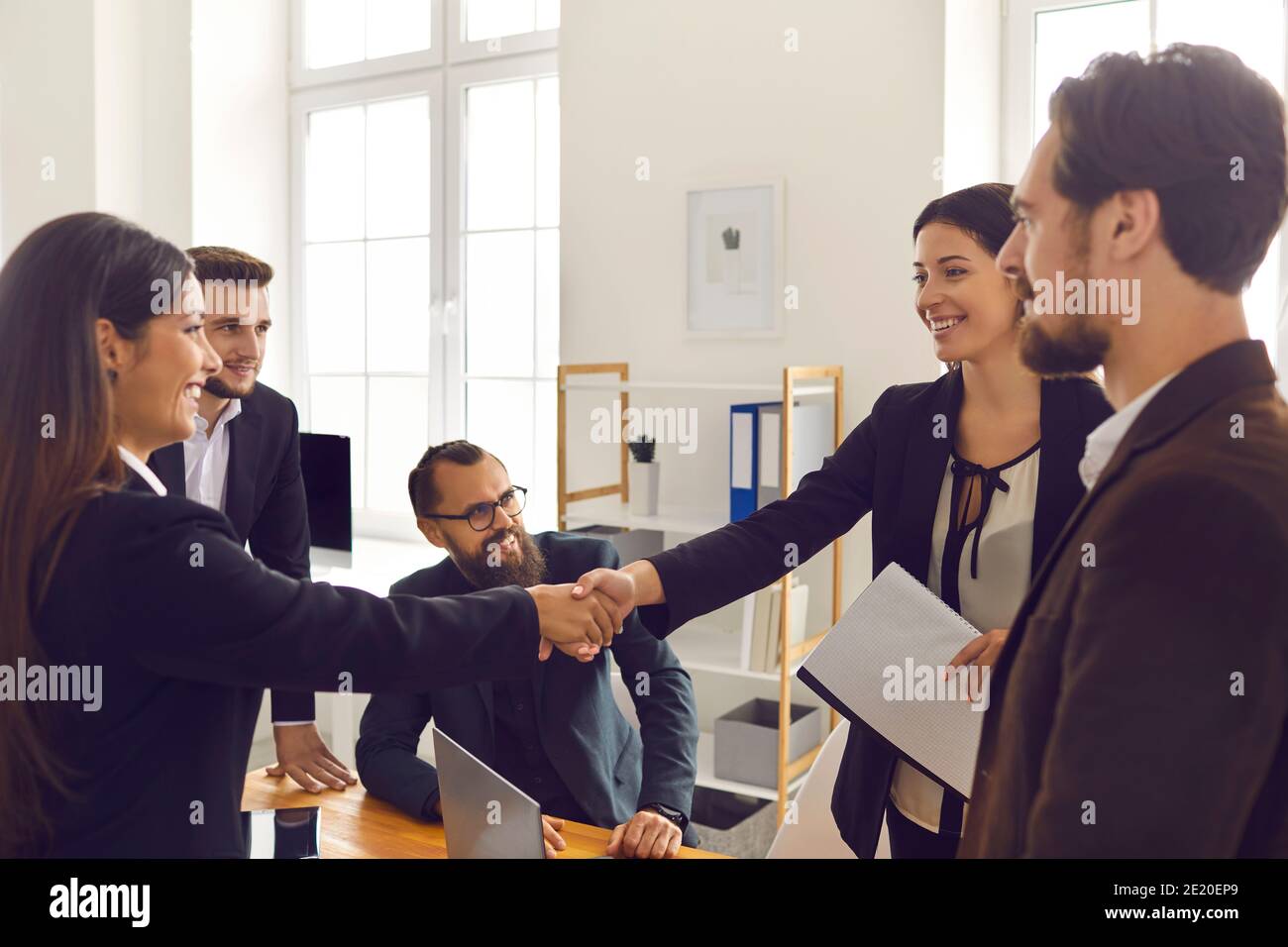 Happy business people closing deal and shaking hands after negotiation ...