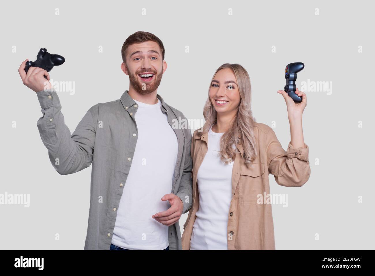 Couple Standing with Joysticks in Hands Smilling Isolated. Happy Couple ...