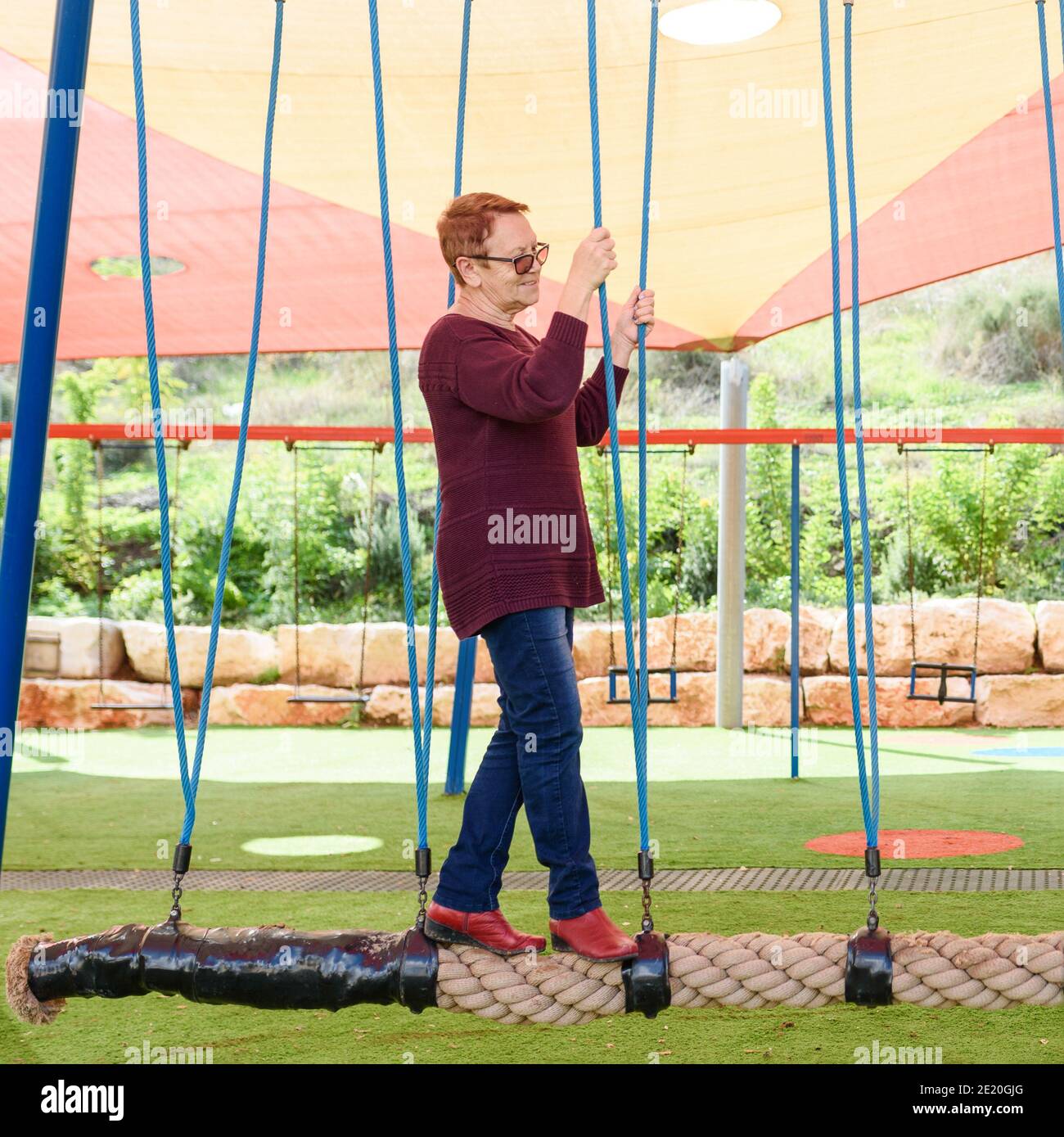 Beautiful old active woman on balance rope in playground Stock Photo ...