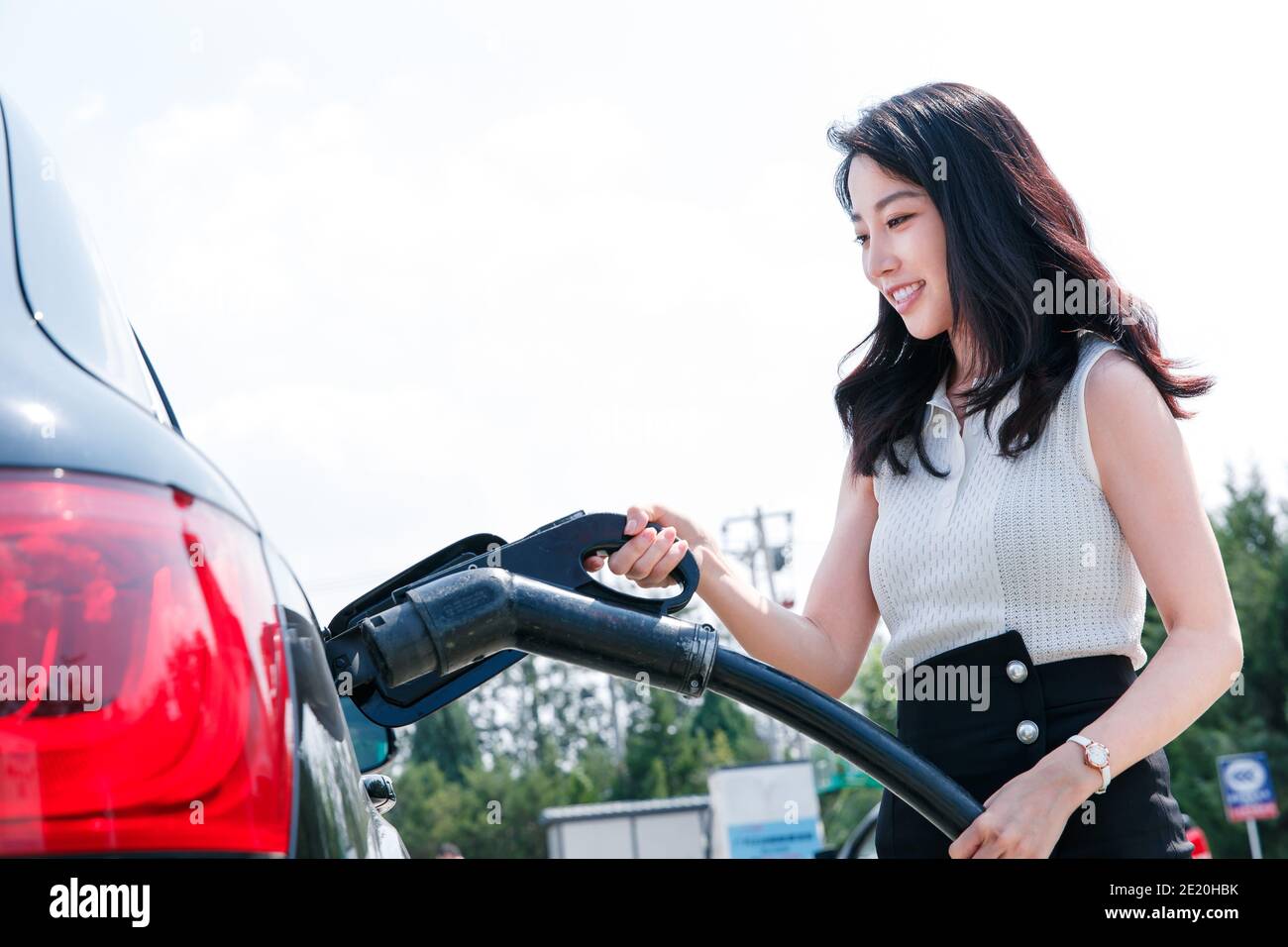 Young women to car battery Stock Photo - Alamy