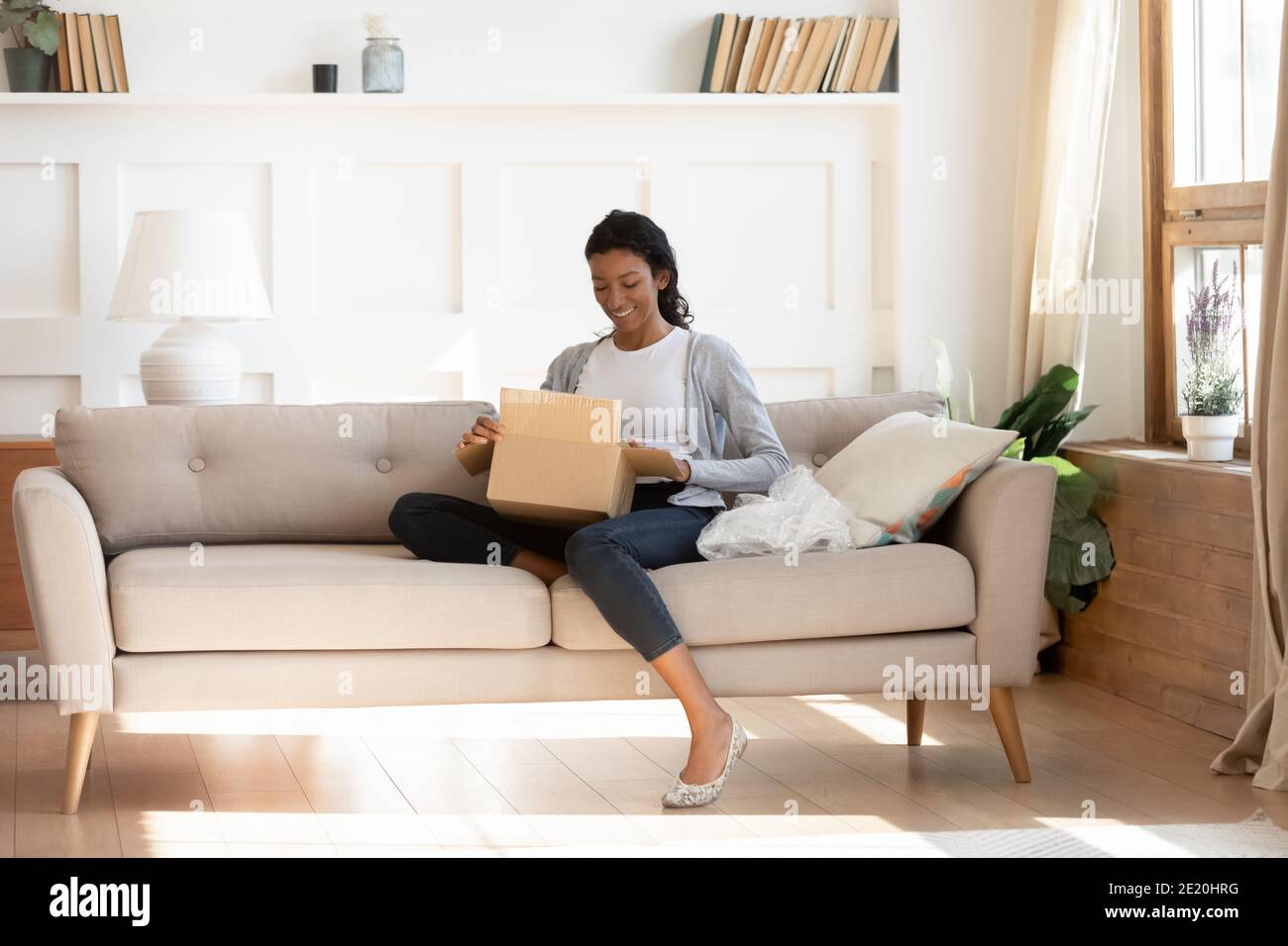 Happy young multiracial female customer opening carton box Stock Photo ...