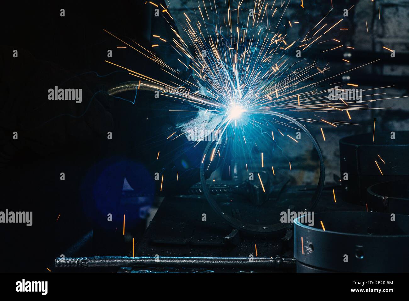 Sparks and blue glow of burning gas of welding in the dark Stock Photo ...