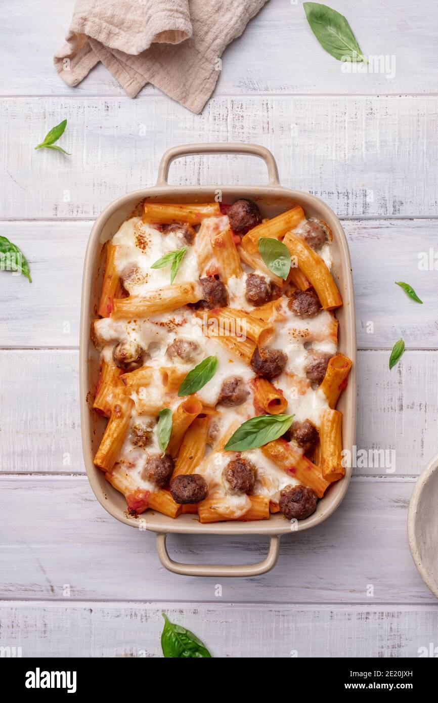 Pasta baked with meatballs and cheese in a skillet on a light slate ...