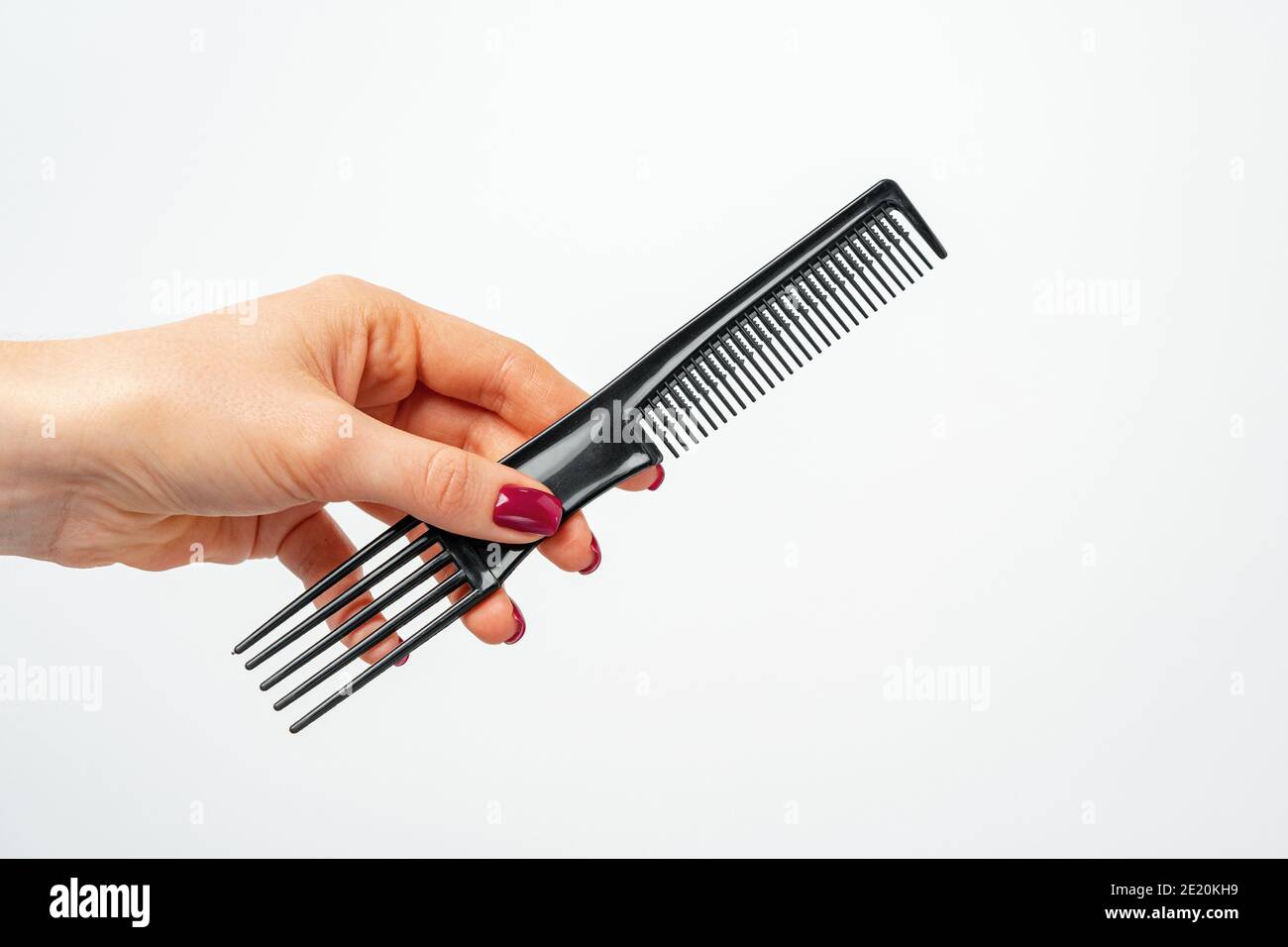 Female hand holding hair comb against white background Stock Photo - Alamy