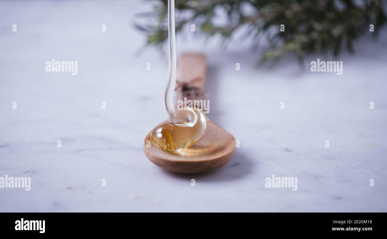 Flow of honey. Golden, yellow, raw honey is dropping from honey dipper ...