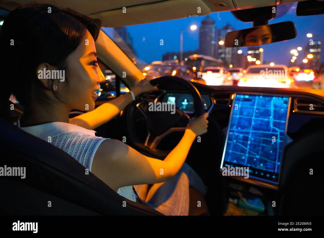 Night driving young woman look at the screen navigation Stock Photo - Alamy