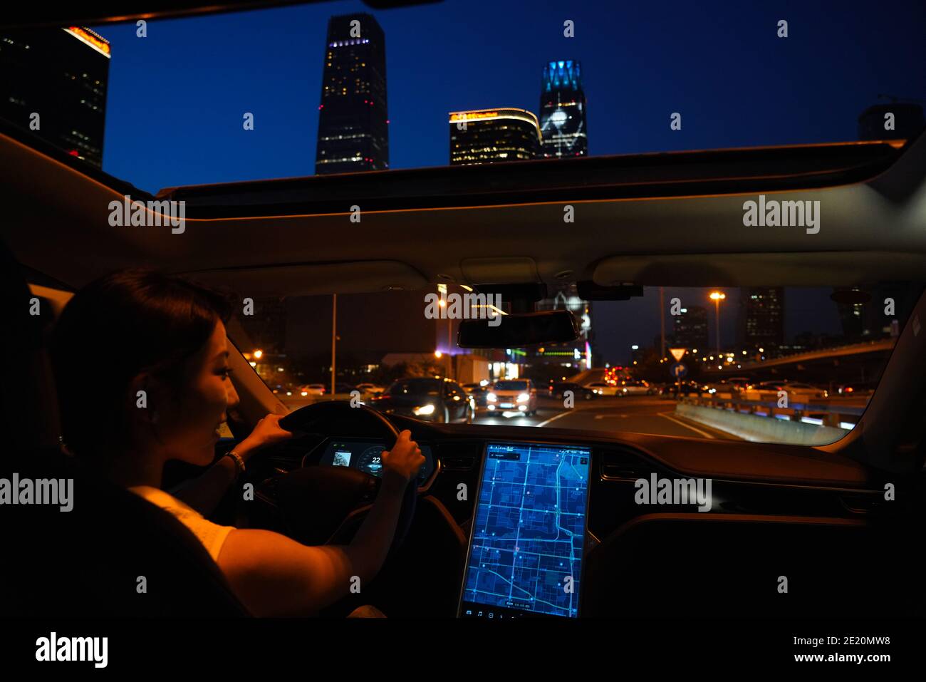 Night driving young woman look at the screen navigation Stock Photo - Alamy