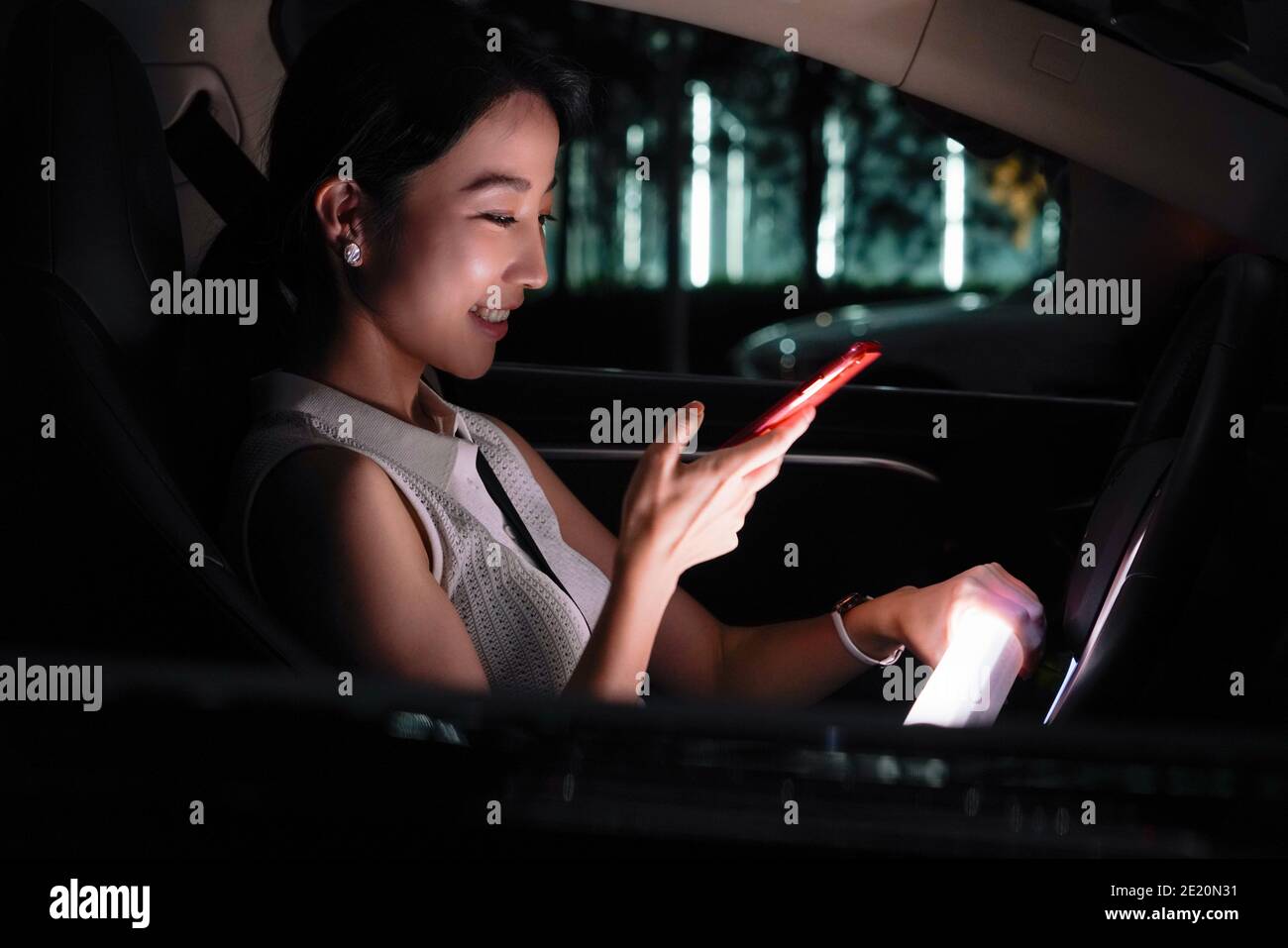 Night young women use a mobile phone in the car Stock Photo - Alamy