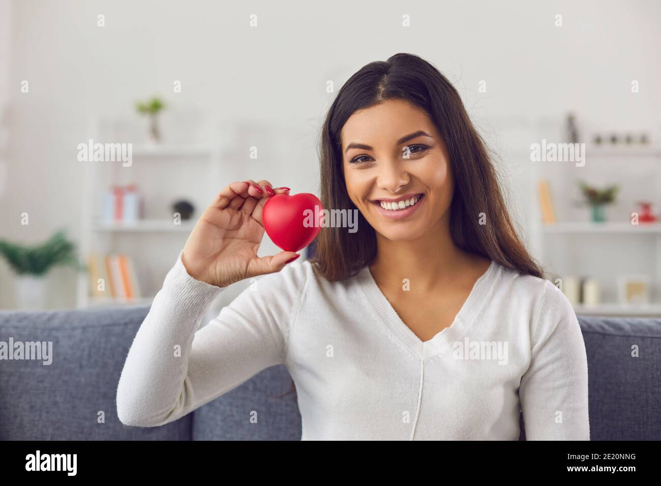 Woman with a heart in her hands smiles, expresses love and affection ...