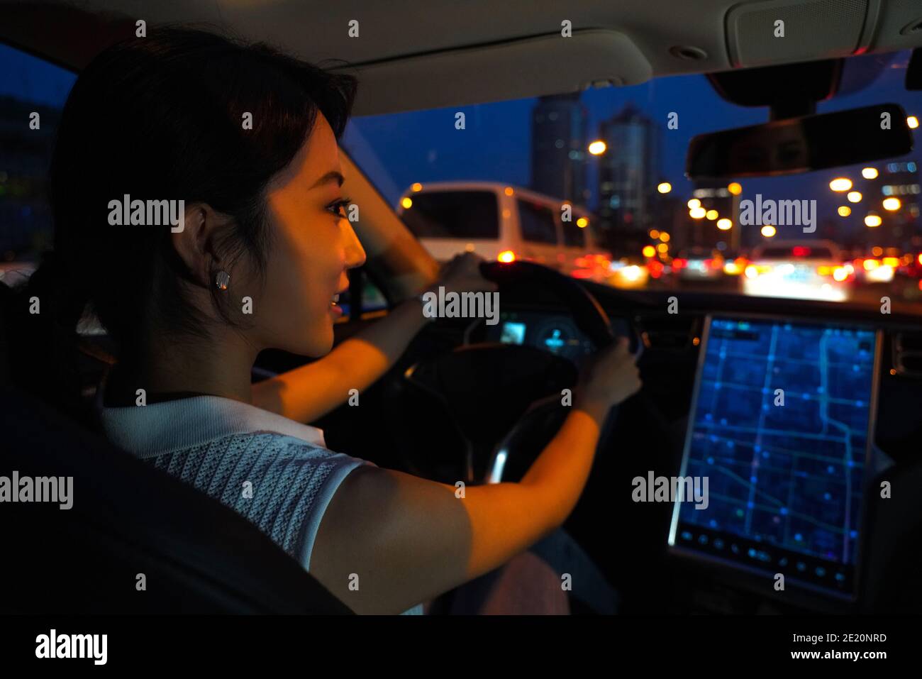 Night driving young woman look at the screen navigation Stock Photo - Alamy