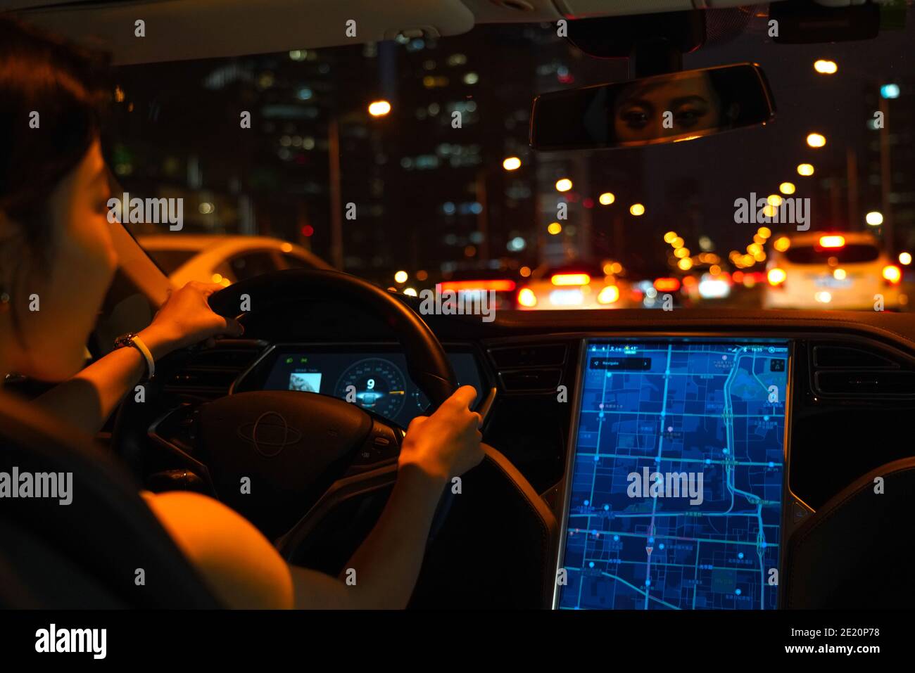 Night driving young woman look at the screen navigation Stock Photo - Alamy