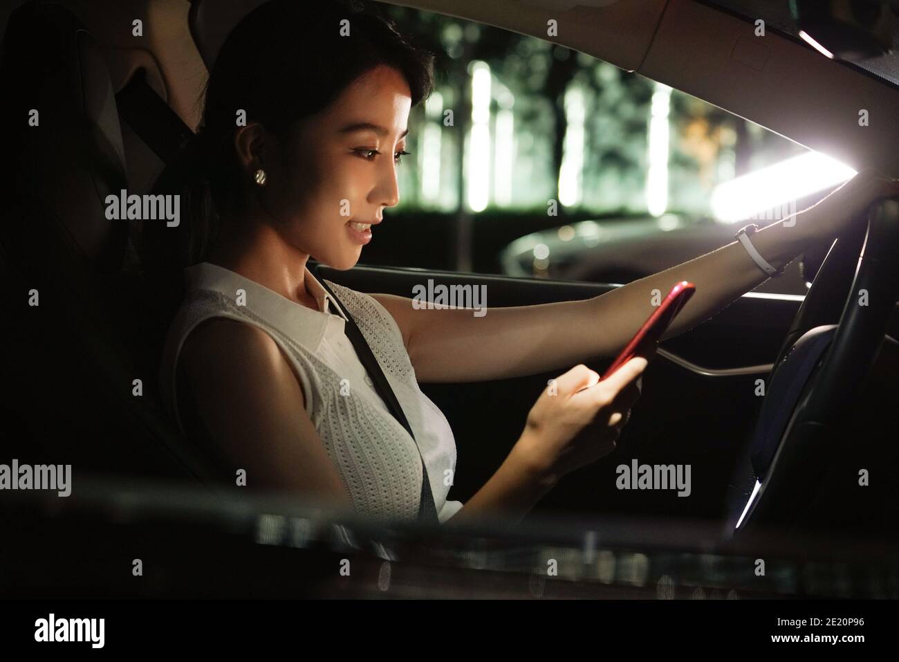 Night young women use a mobile phone in the car Stock Photo - Alamy