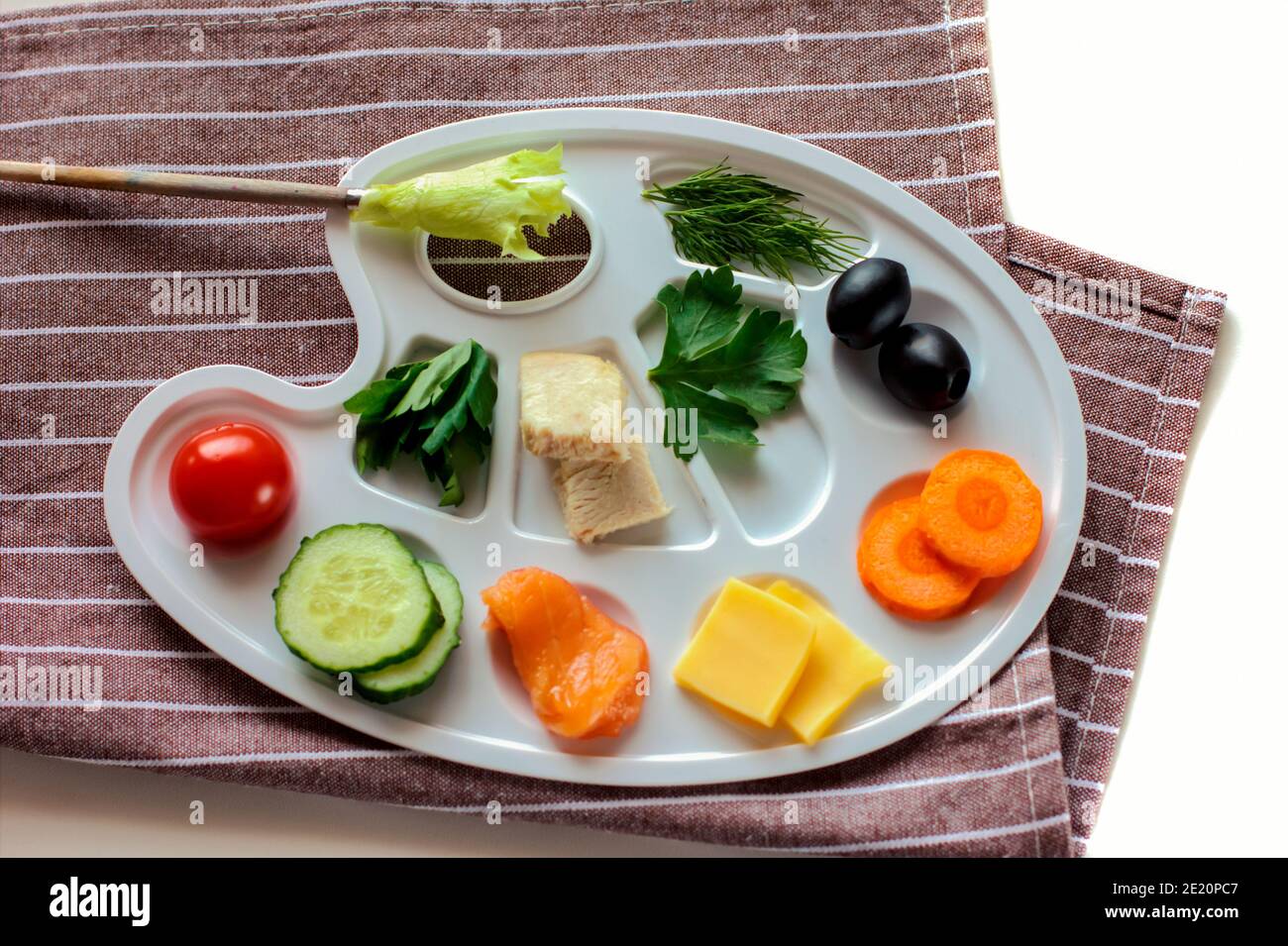 palette with tasty colorful vegetables, fish and greens, creative food ...