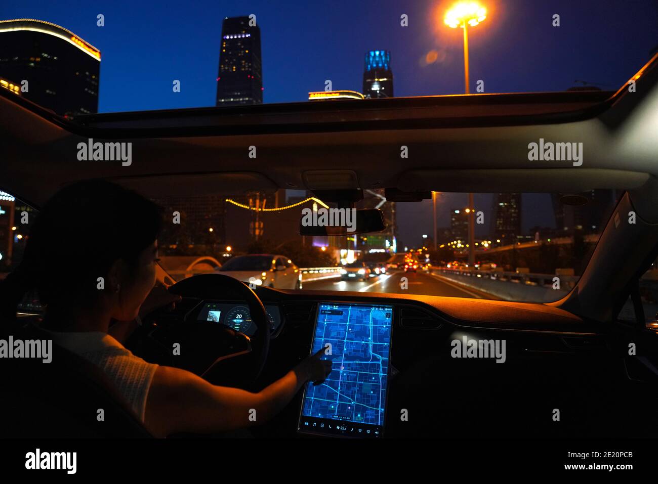 Night driving young woman look at the screen navigation Stock Photo - Alamy