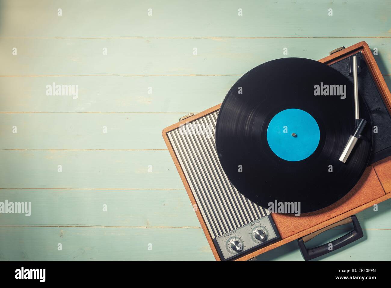 Vintage gramophone with a vinyl record on green wooden table, top view ...