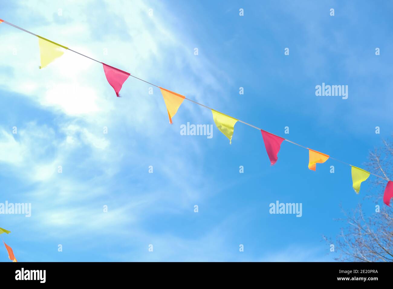 colorful bunting party flags over blue sky background. open air party ...