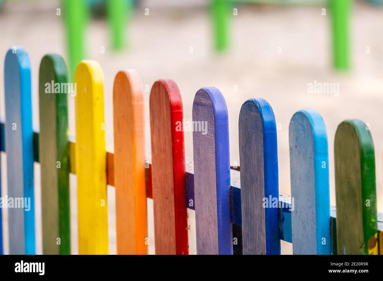 Part of wooden, rainbow colorful painted fence on a sunny hot summer ...