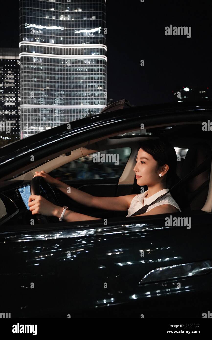 Beautiful young woman driving at night Stock Photo - Alamy