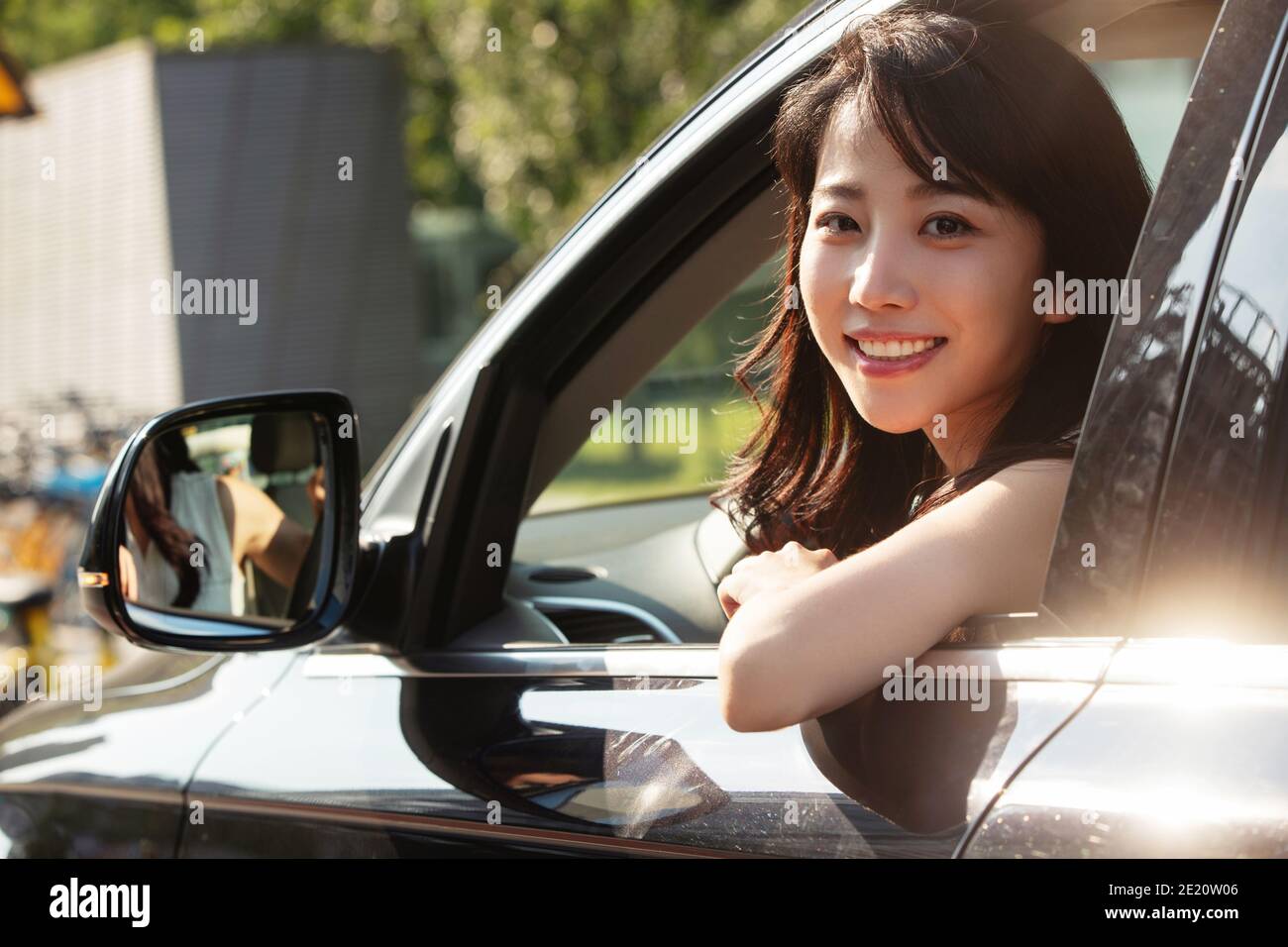 Beautiful young woman out of driving a car Stock Photo - Alamy