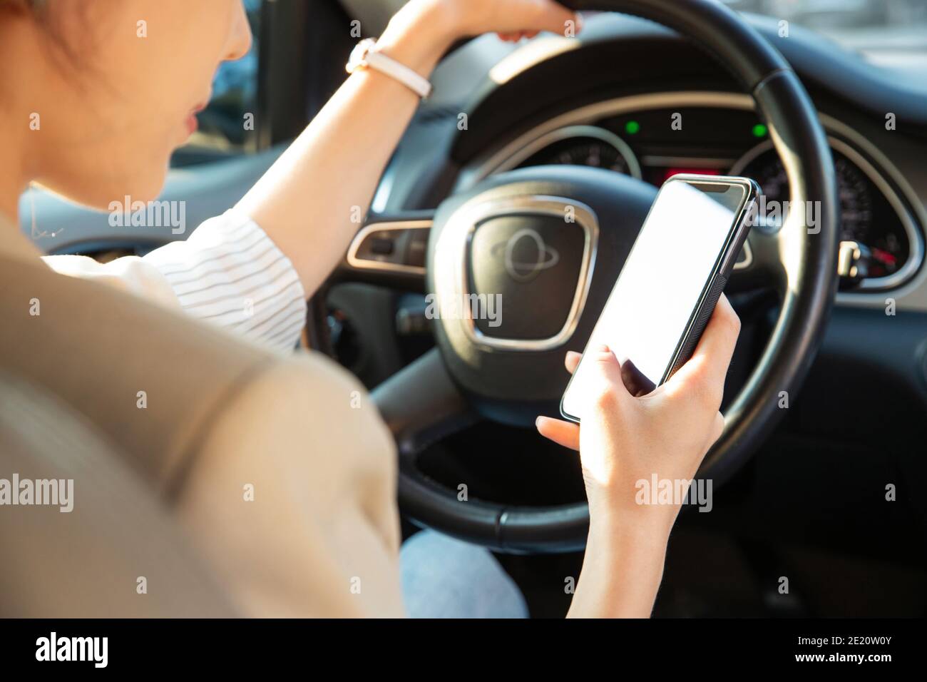 Young woman driving the use of mobile phones Stock Photo - Alamy
