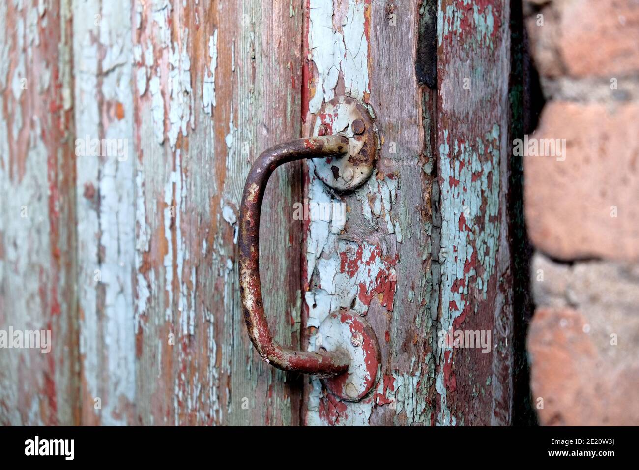 Rusty iron handle on a old wooden door with a peeled blue paint ...