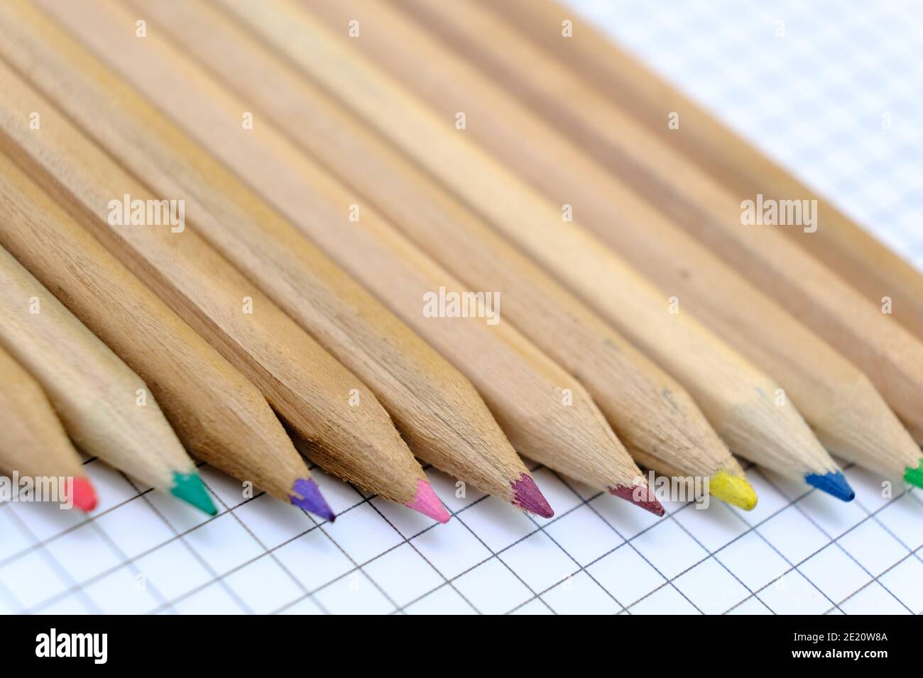 Closeup set of multicolored pencils on the checkered paper sheet of ...