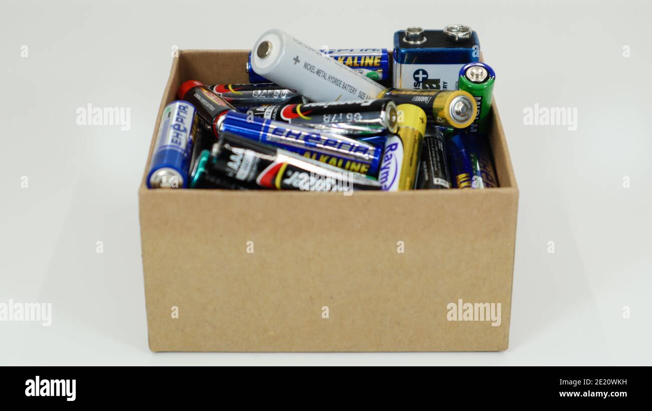 A cardboard box on a white background full of used household AA, AAA ...