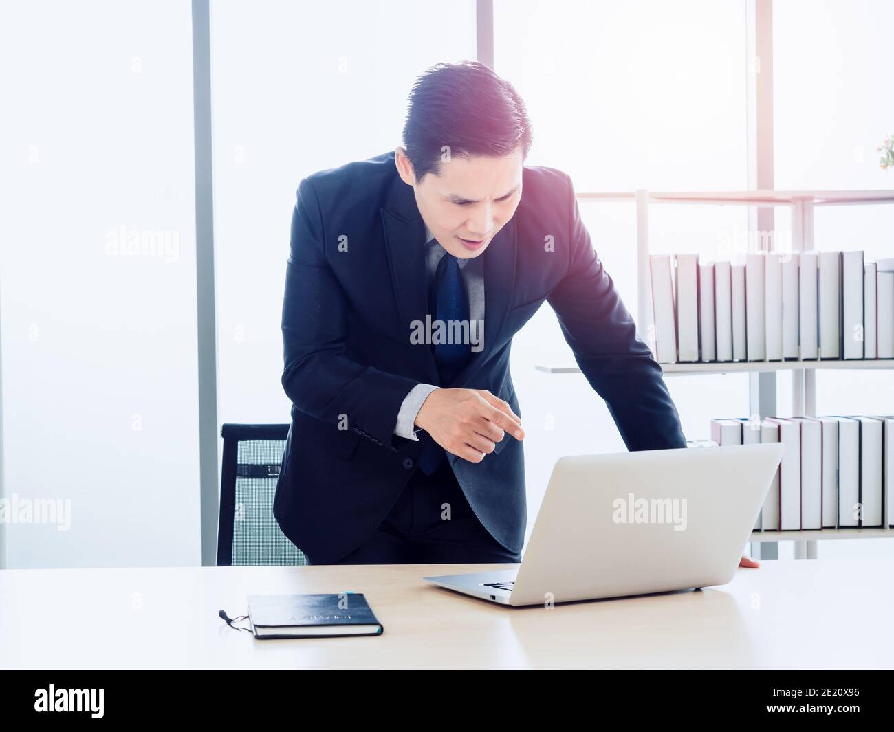 Handsome Asian businessman in suit video call, pointing to laptop ...