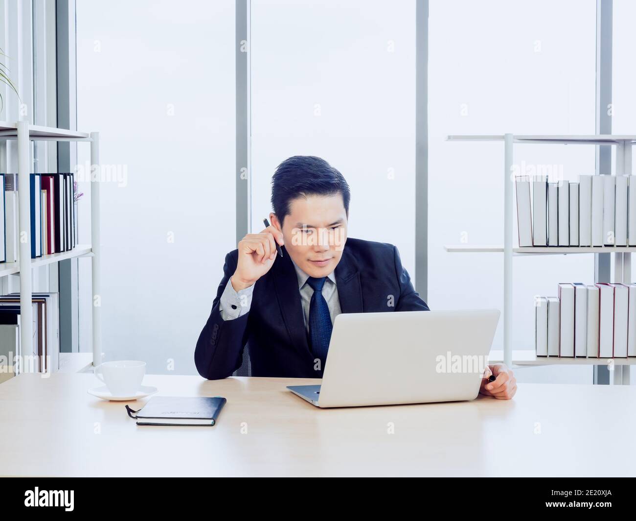 Handsome Asian businessman in suit concentrate watching on screen while ...